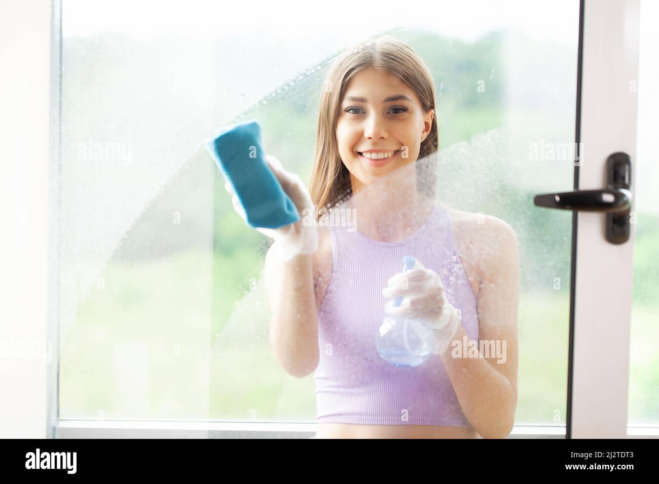 Young Smiling Woman Washing Window with Sponge Stock Photo - Alamy