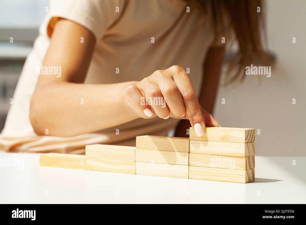 Woman hand stacking wooden blocks in shape of staircase Stock Photo - Alamy