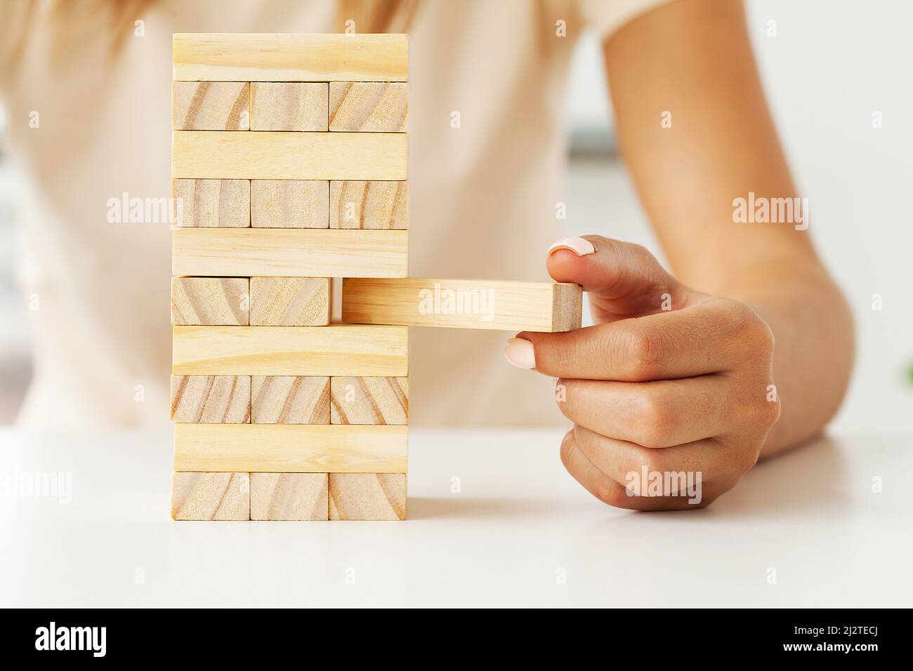 Hand of a young business woman To play wood block game with strategy ...