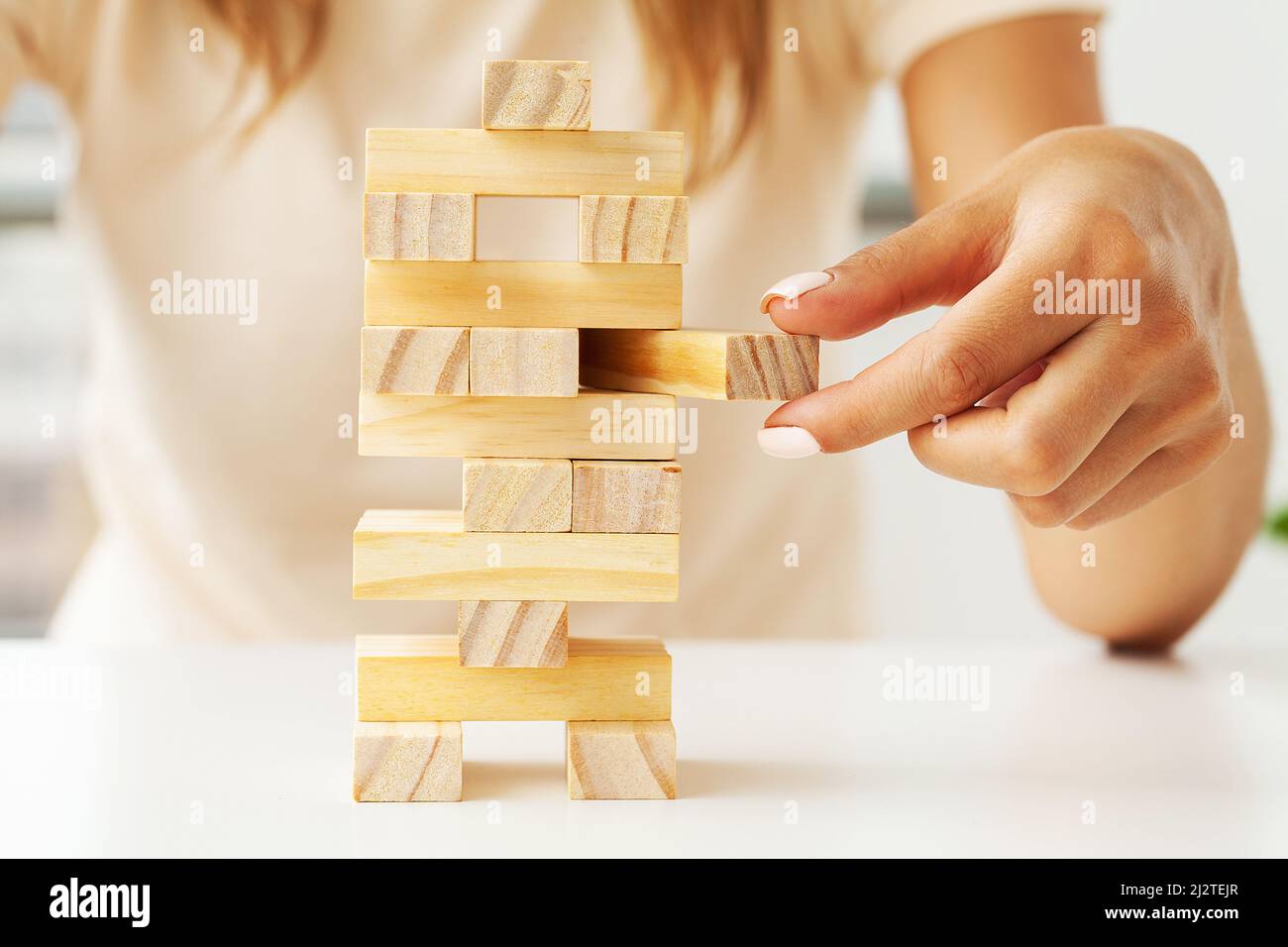 Hand of a young business woman To play wood block game with strategy ...
