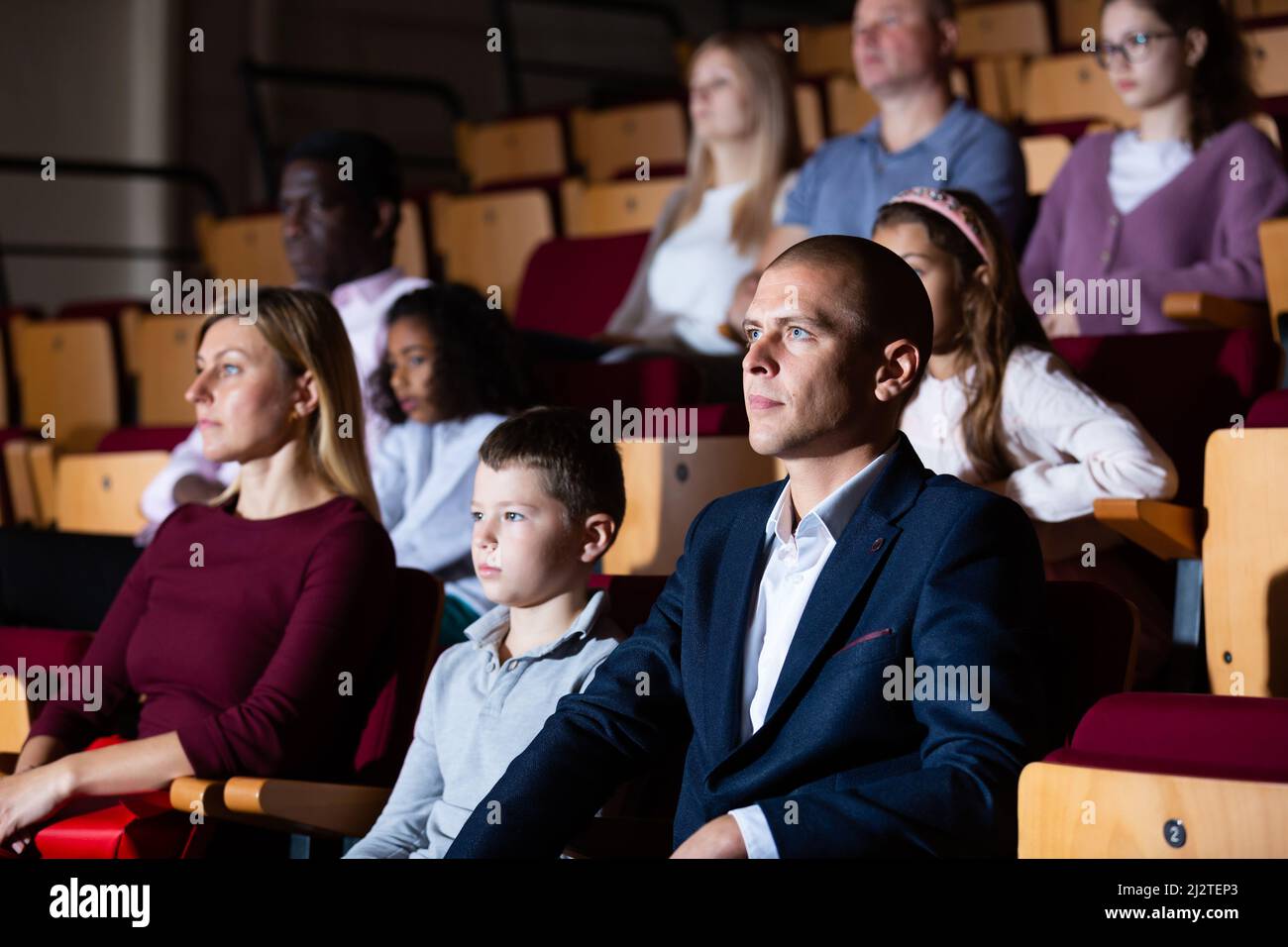 Family with son watching spectacle in theater Stock Photo - Alamy