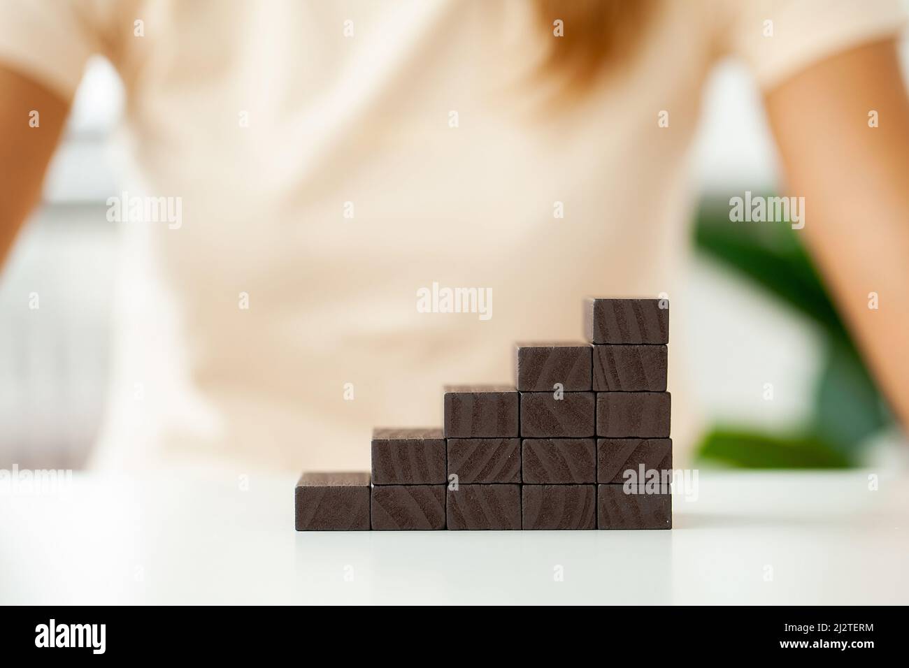 Woman hand stacking wooden blocks in shape of staircase Stock Photo - Alamy