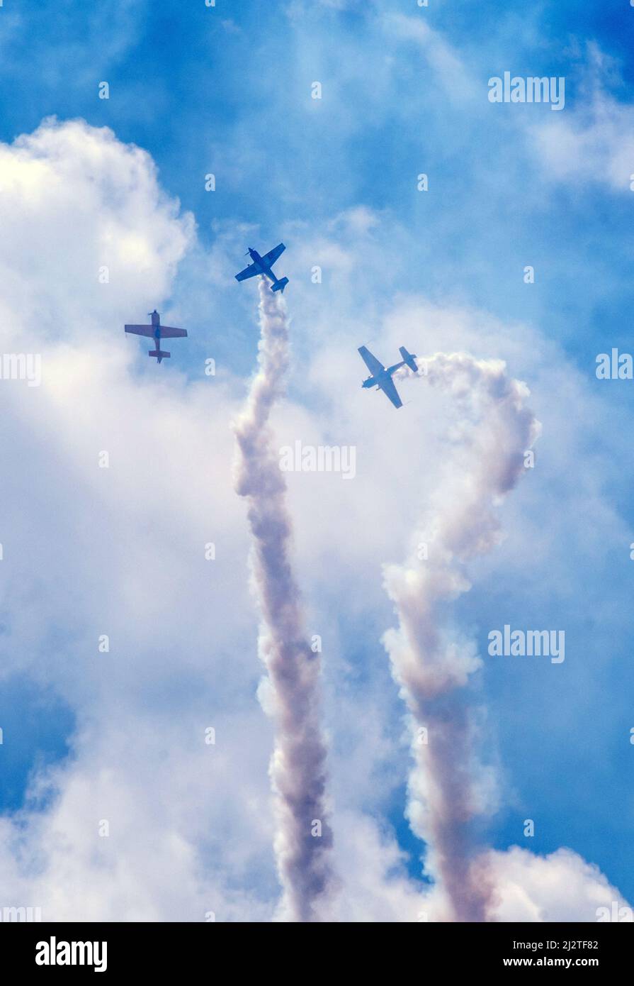 Three planes perform stunts in a aviation show, high in the sky in ...