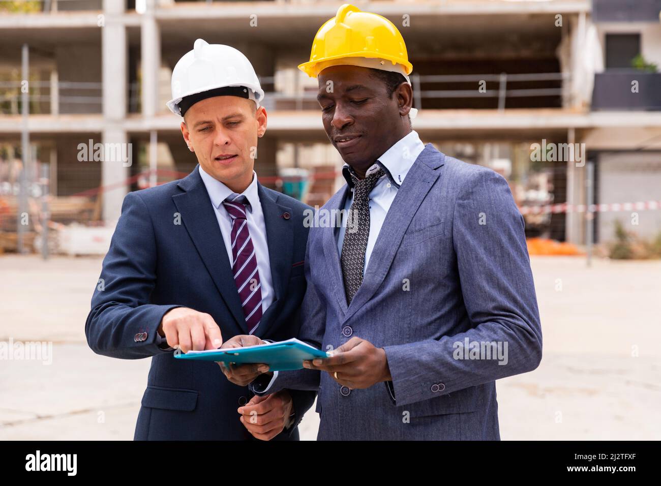Two engineers discussing project documentation Stock Photo - Alamy