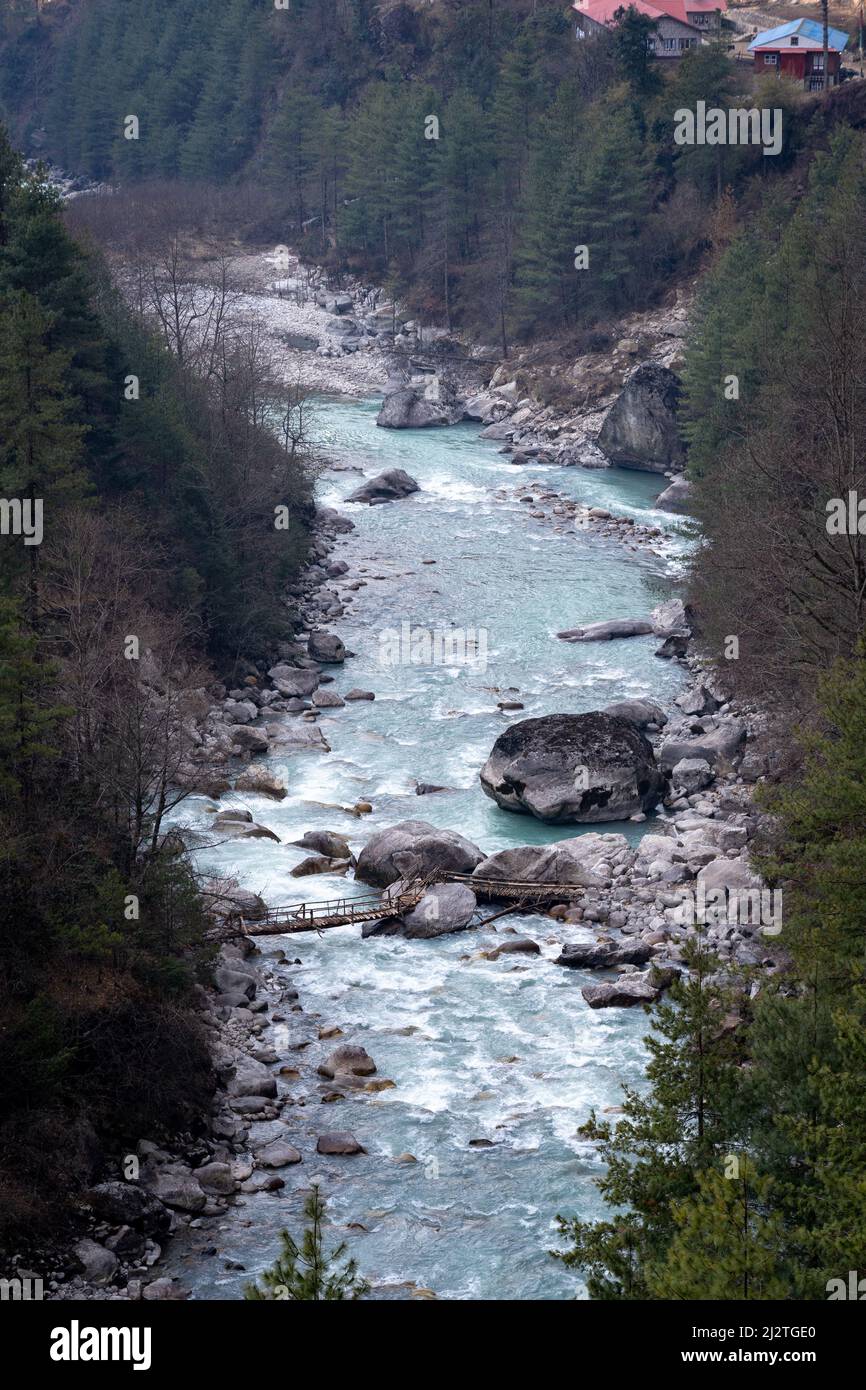 A small wooden bridge over a river in a deep valley Stock Photo - Alamy