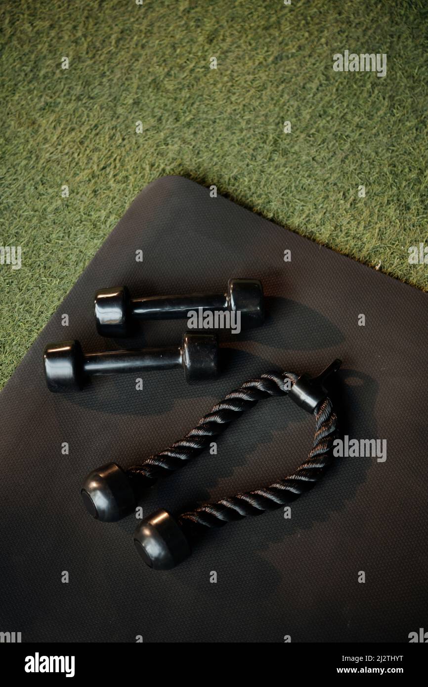 Dumbbells and triceps rope on gym floor, view from above Stock Photo ...