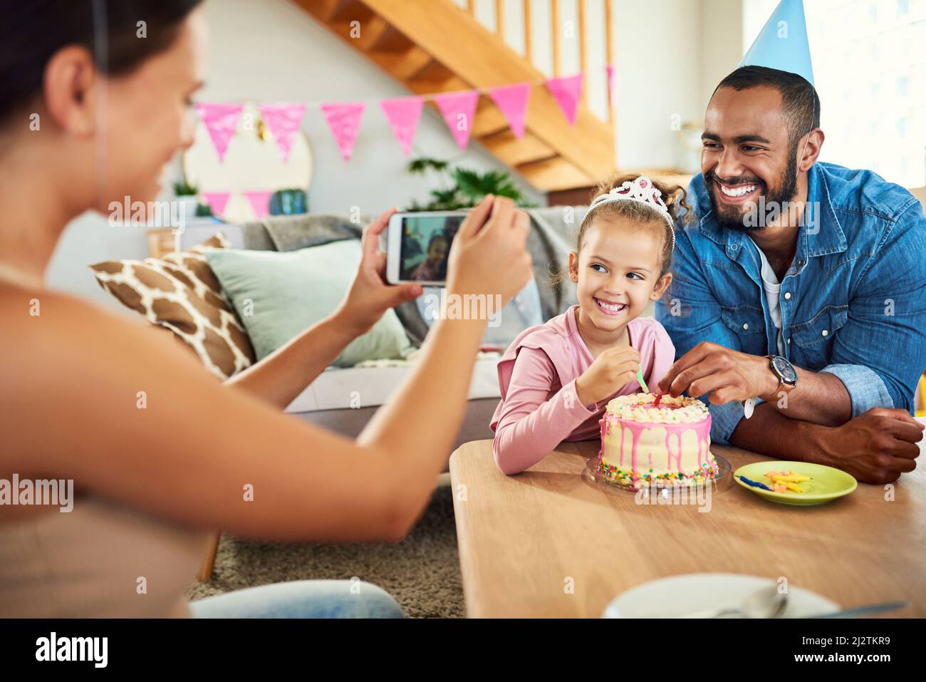 Say cheese. Shot of a young mother taking a photo at her daughters ...