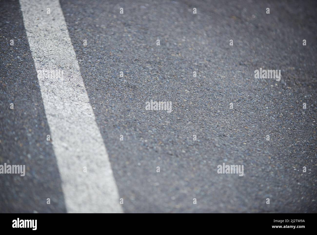 Hit the road. Closeup shot of a white dividing line on an asphalt road ...