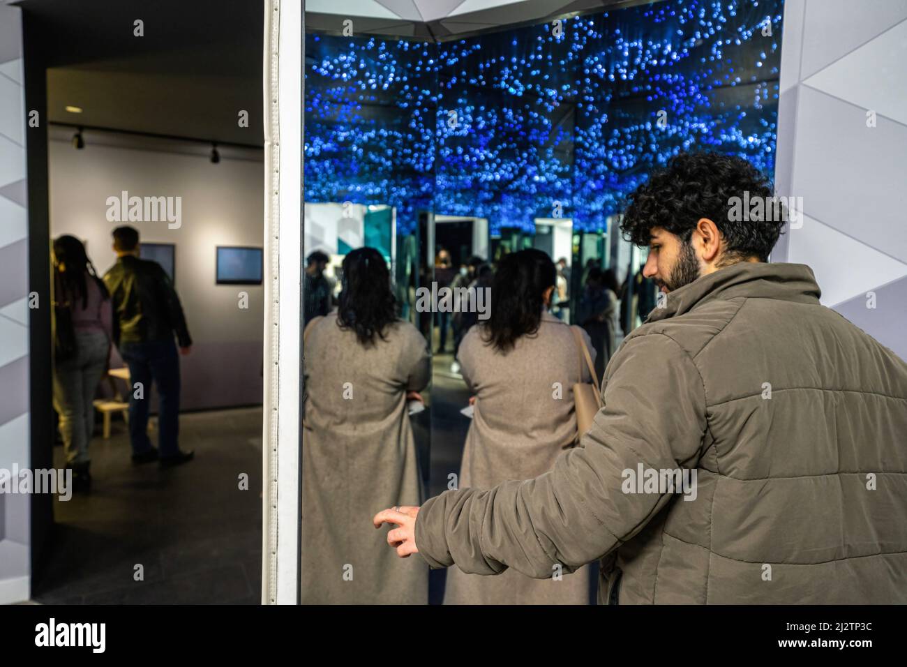 A young couple opens the door to an Infinity Room. Visitors view and experience the interactive ...