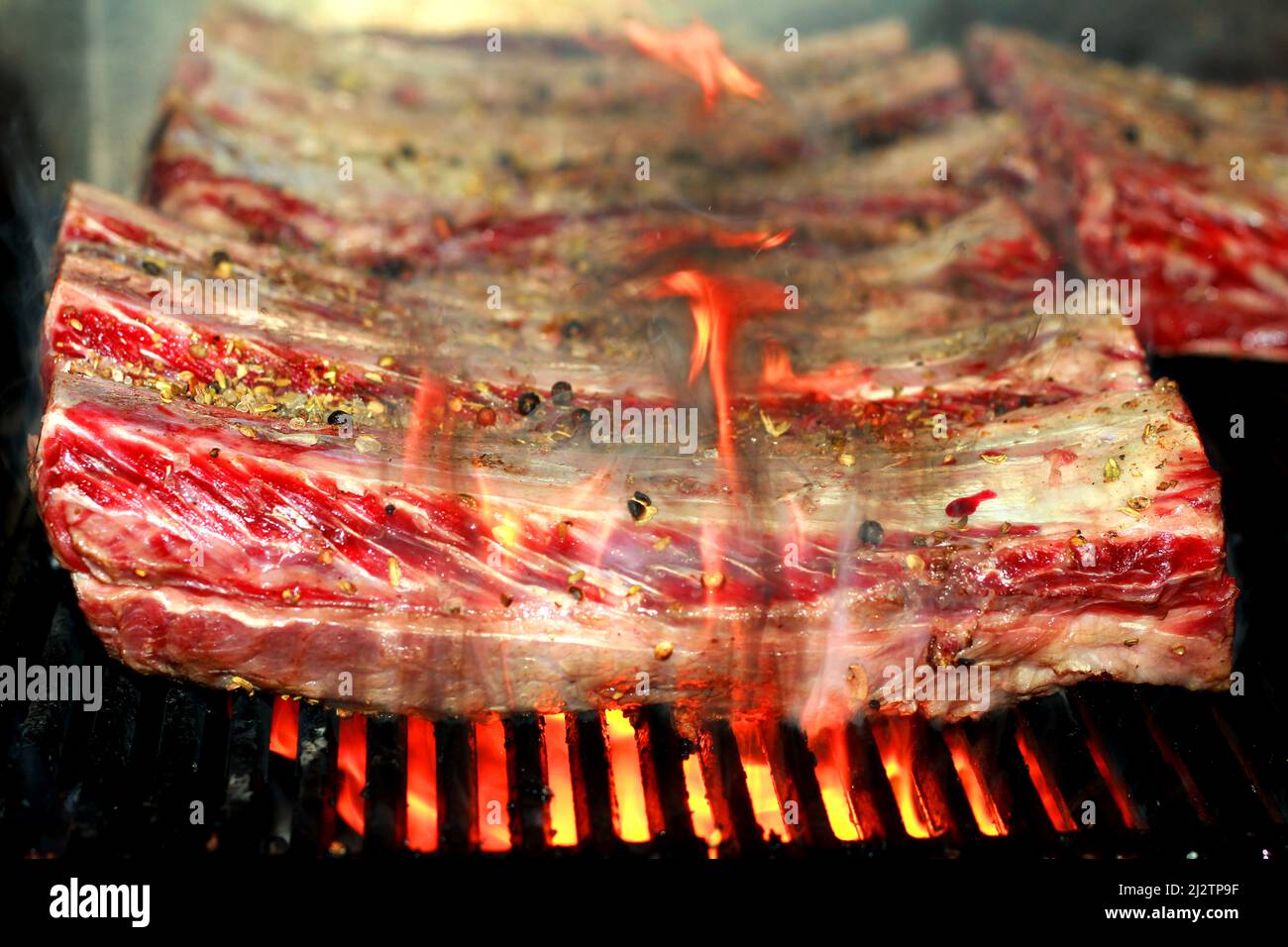 spice marinated american angus beef ribs on a barbecue grill with flame ...