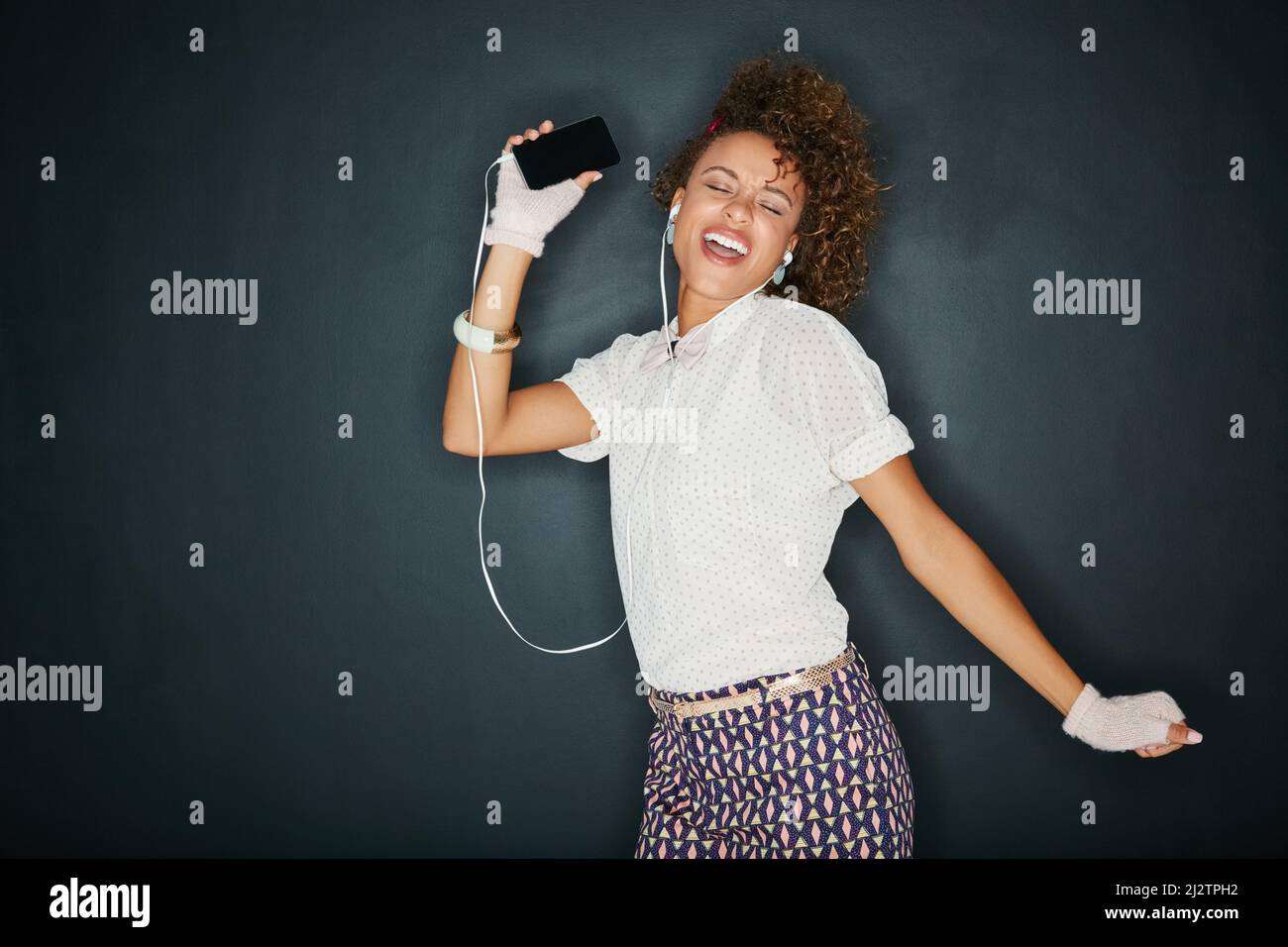 When an epic beat drops. Studio shot of an attractive young woman ...