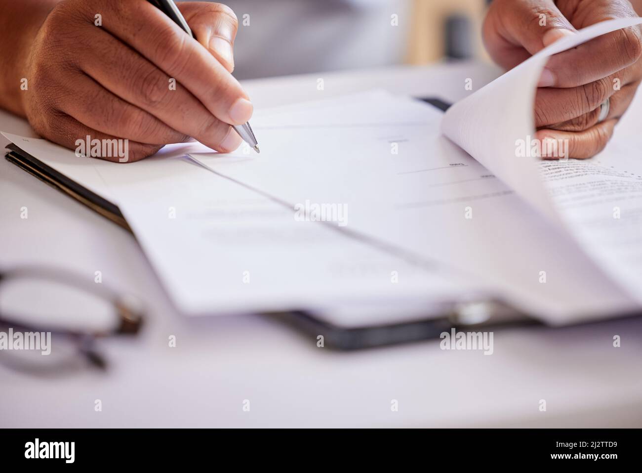 Filling in some paperwork. Cropped shot of an unrecognizable ...