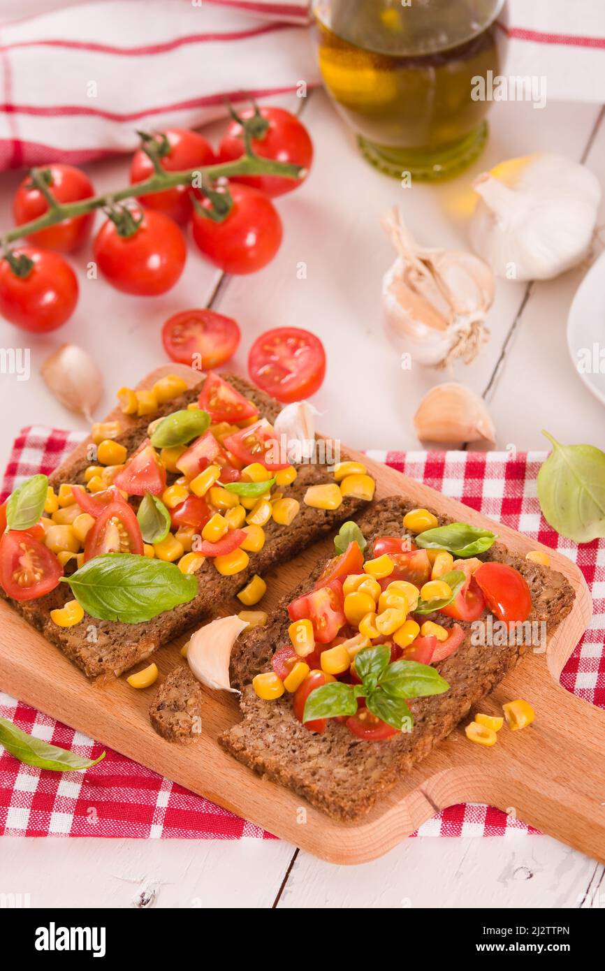 Rye bread withsweet corn, basil and tomato Stock Photo - Alamy