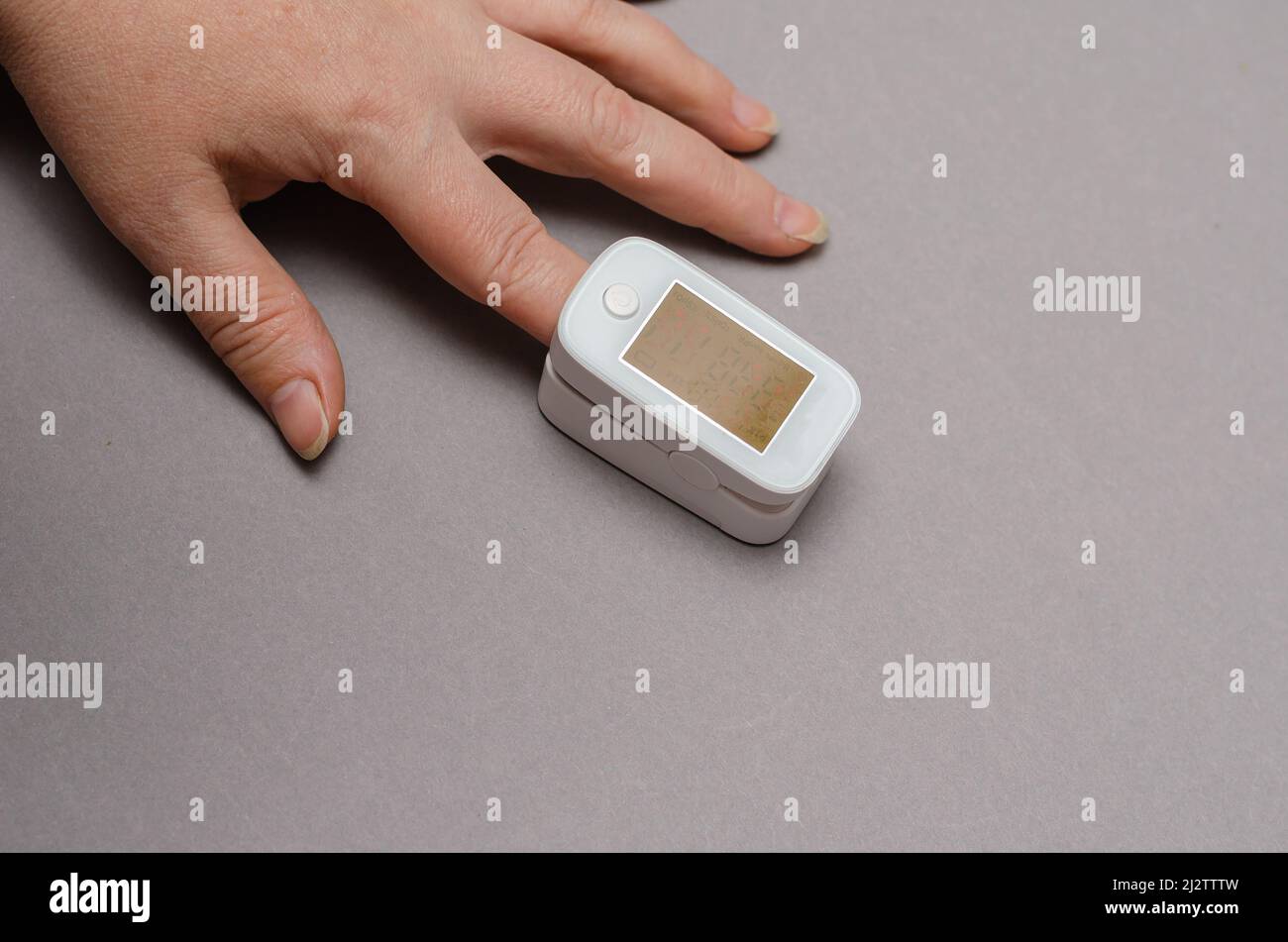 The oximeter is worn on the index finger of a woman's hand. A device ...