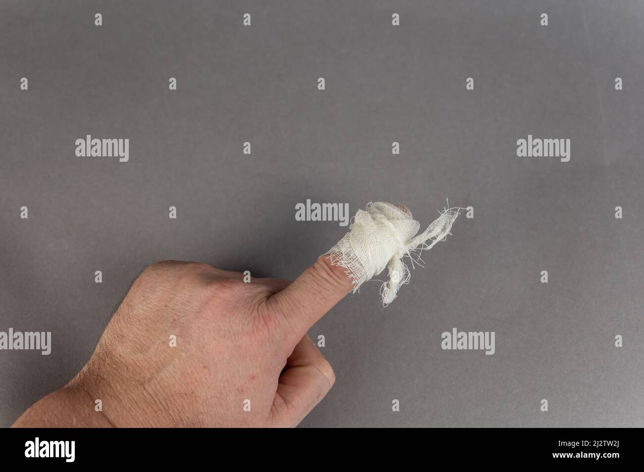 The hand of a mature man with a bandaged index finger. The man holds ...
