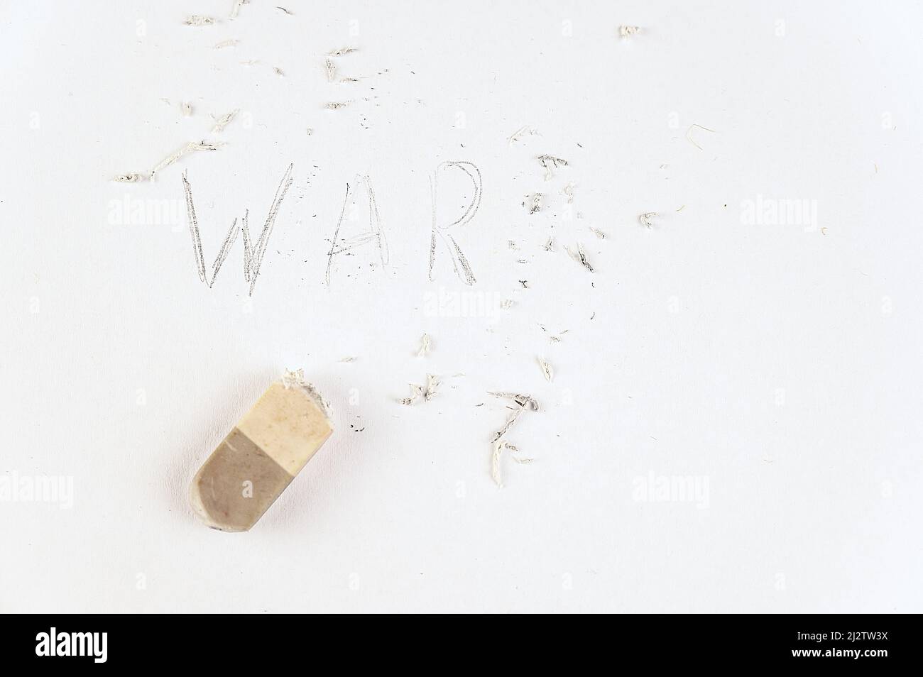 Half-erased with an eraser is the word WAR. Handwritten word on white ...