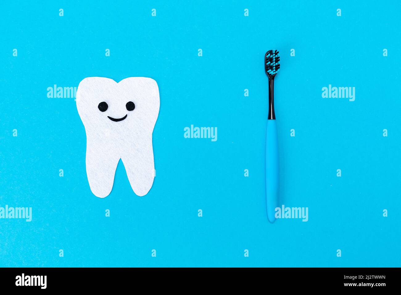 A plastic toothbrush and cartoon tooth cut out of felt on a blue ...