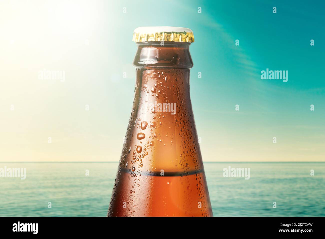 Close-up of the neck of wet glass bottle of dark beer against the ...