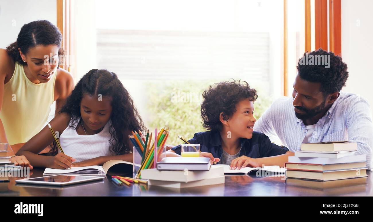 Helping the little ones with their homework. Cropped shot of parents ...