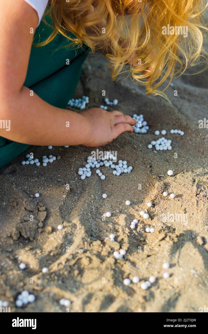 Close up shot of a little girl's hand playing with styrofoam from ...