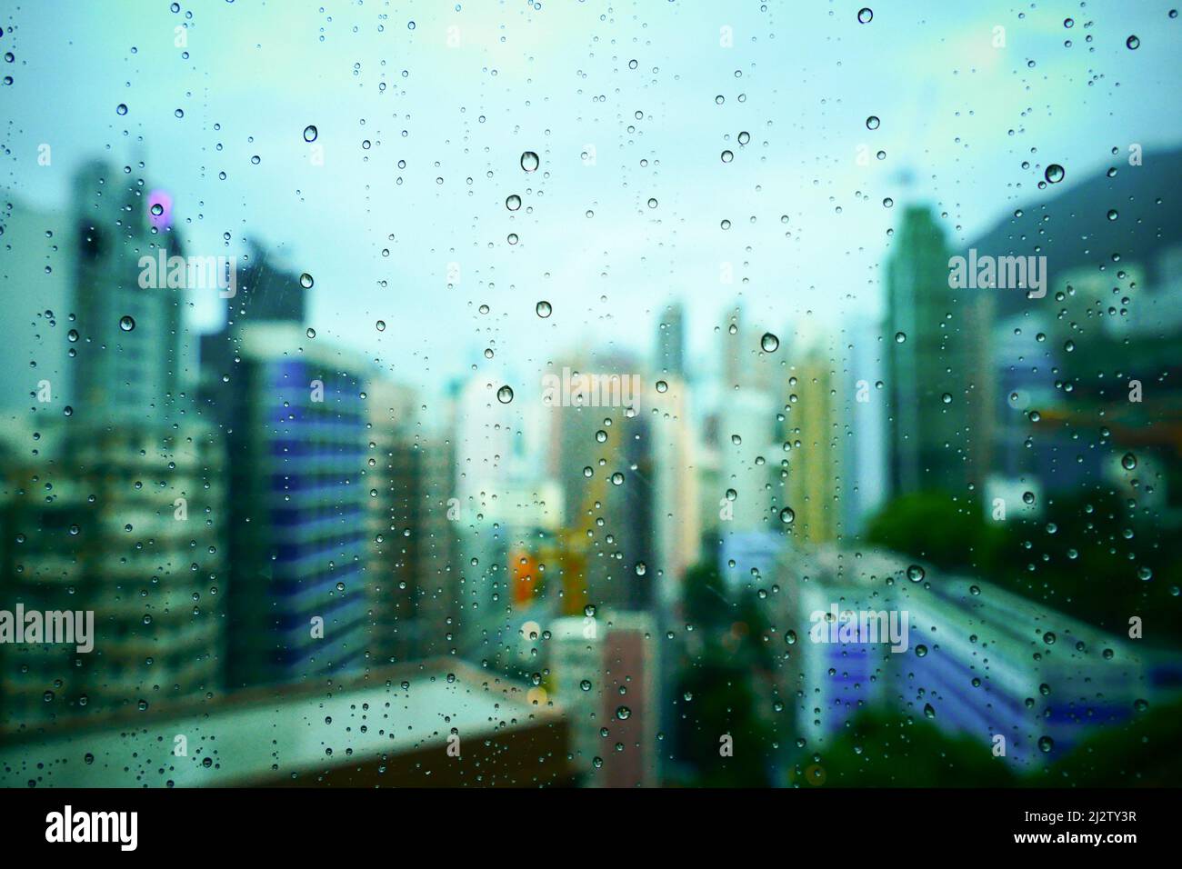 water drops on window glass during rain day. buildings in Sheung Wan ...