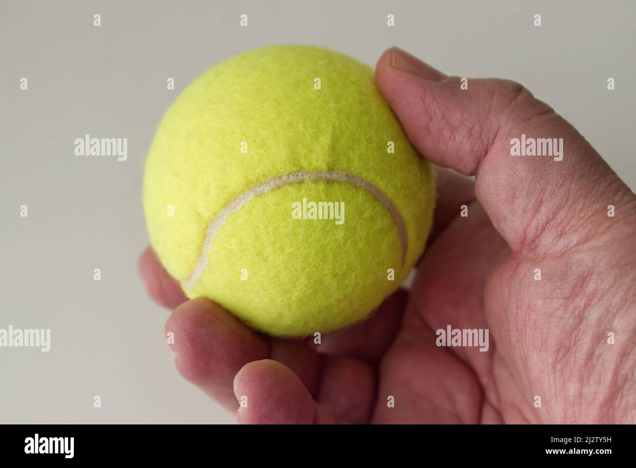 Male hold a tennis ball in hand isolated on white background Stock ...