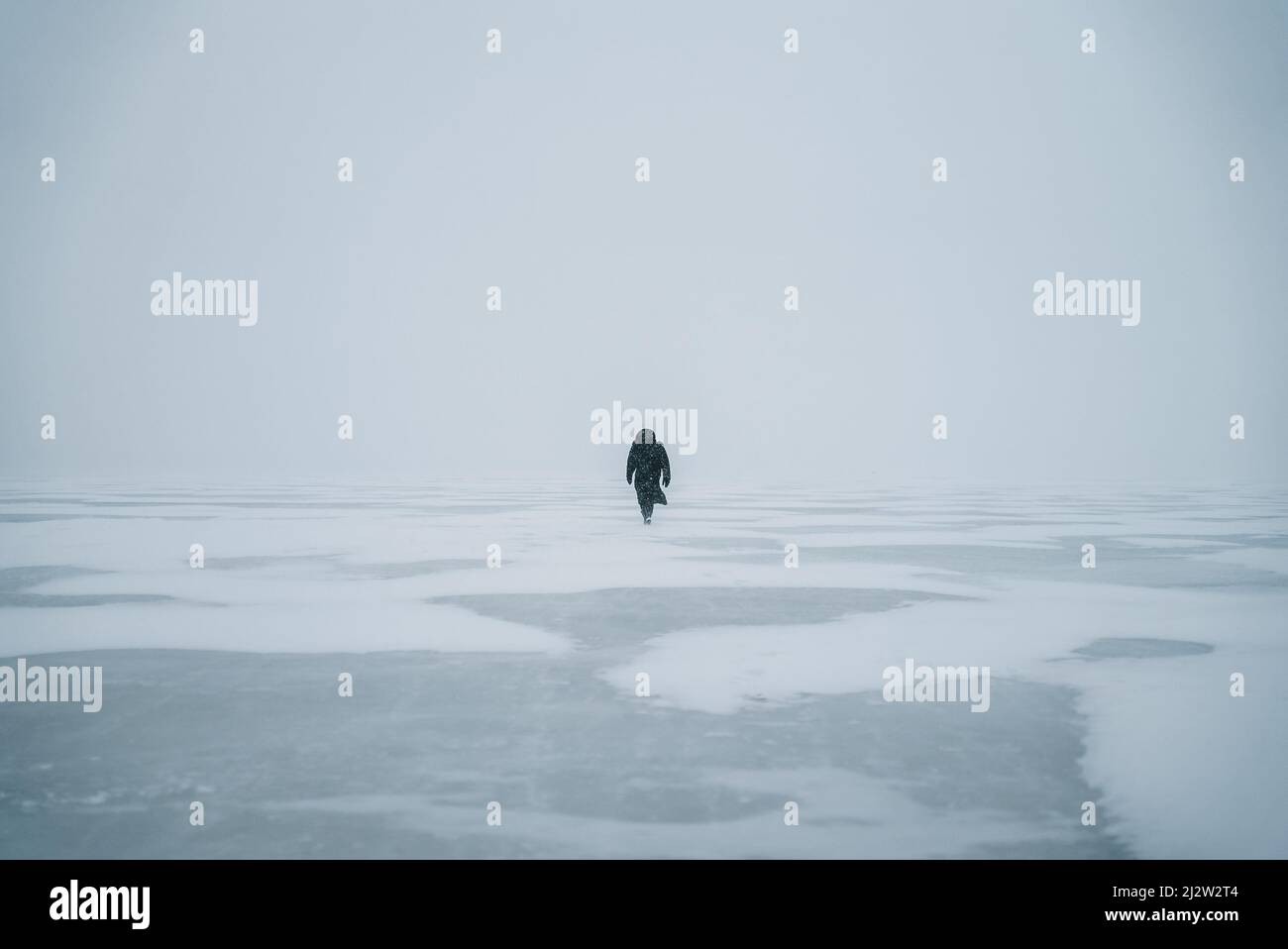 Man walking alone on ice, snow Stock Photo - Alamy