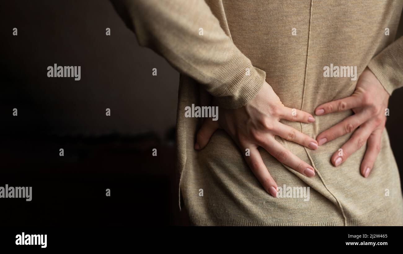 Long working hours and health. Young girl with back pain. Woman with ...