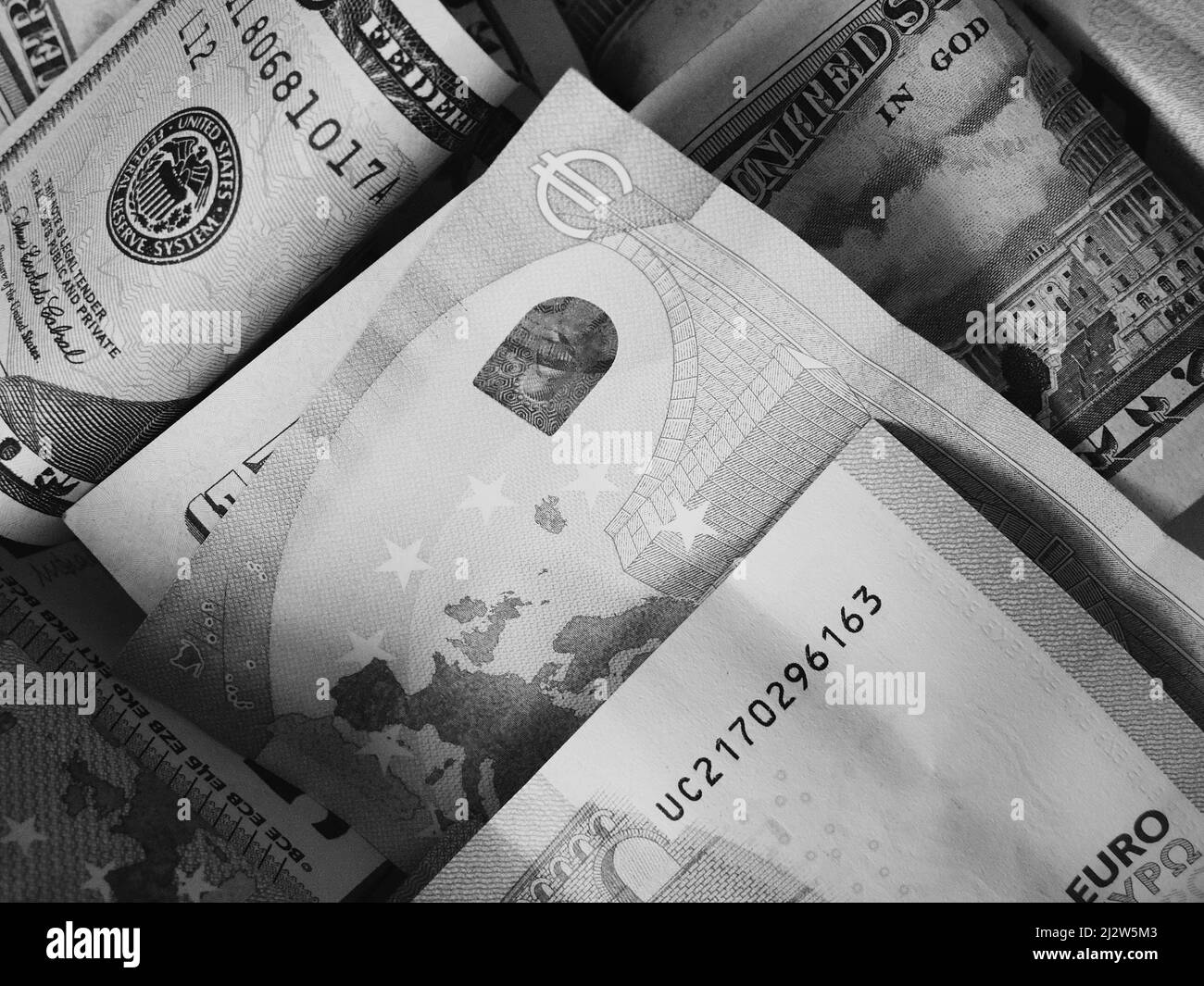 Cash banknotes dollars and euros are mixed up, a close-up shot. Black ...