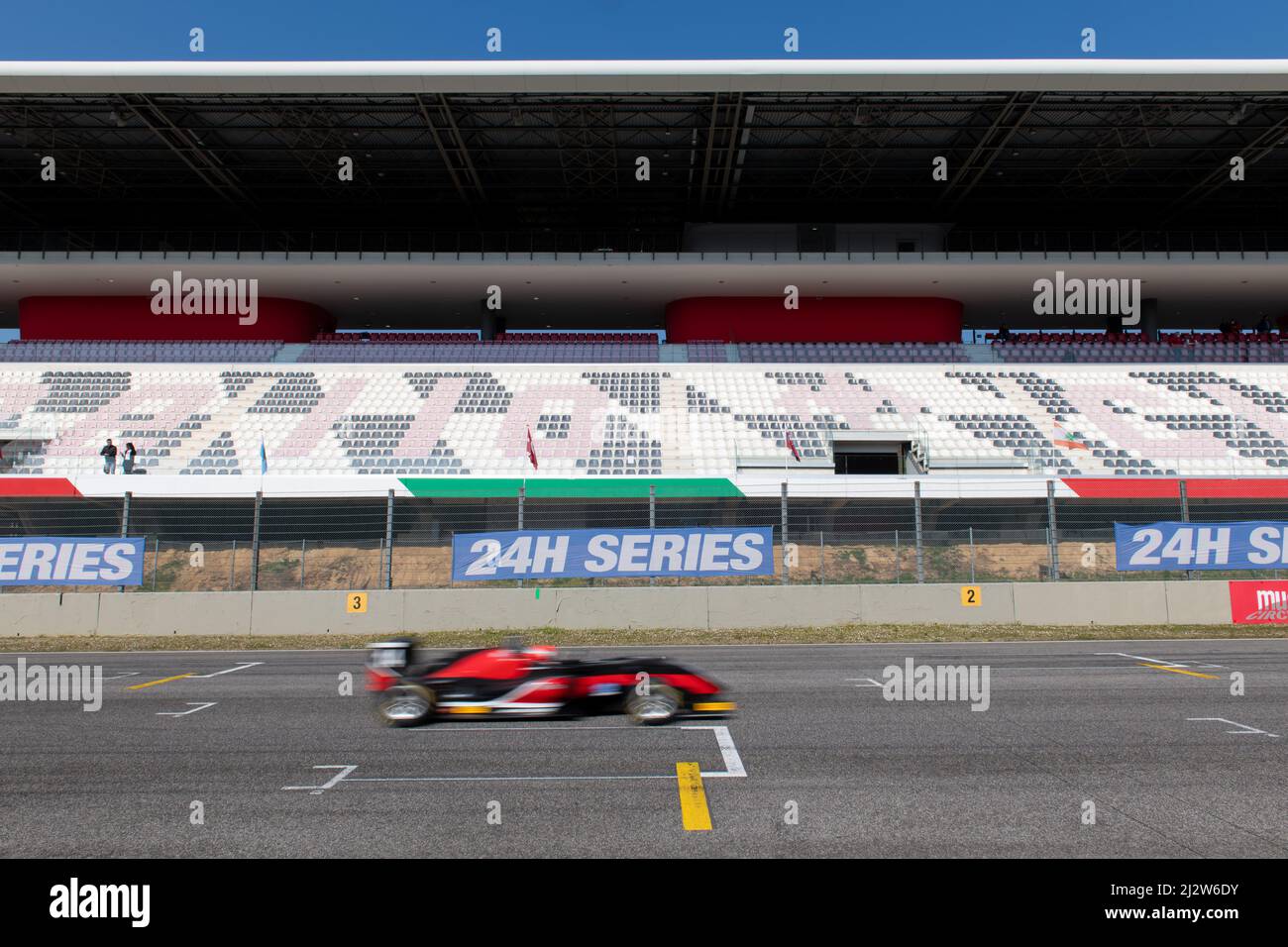 24h series board on circuit grandstands with blurred race car fast on ...