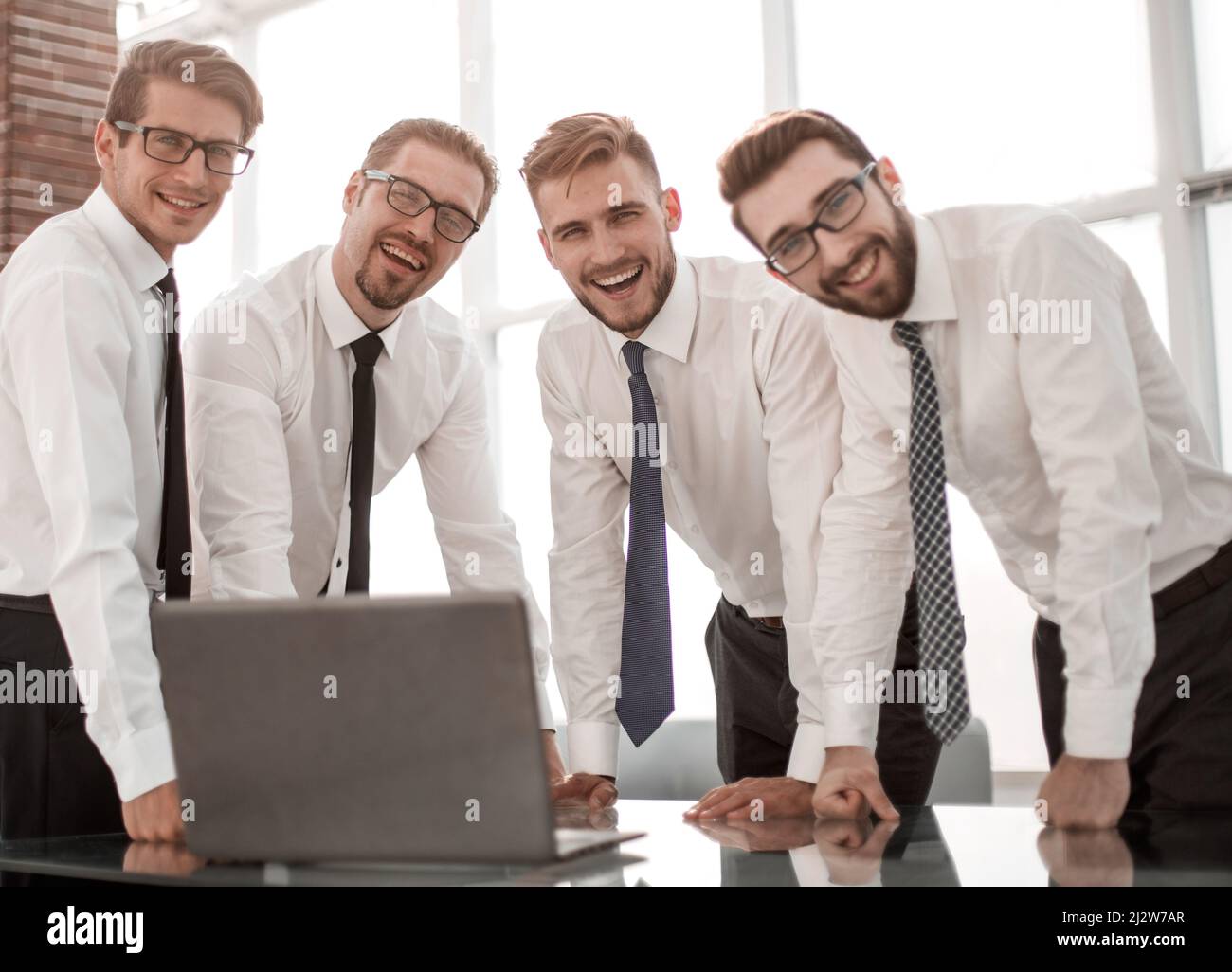 close up.smiling group of employees standing near the office Desk Stock ...