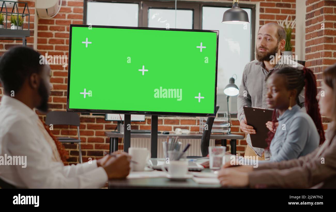 Workmates using monitor with mockup green screen in startup office ...