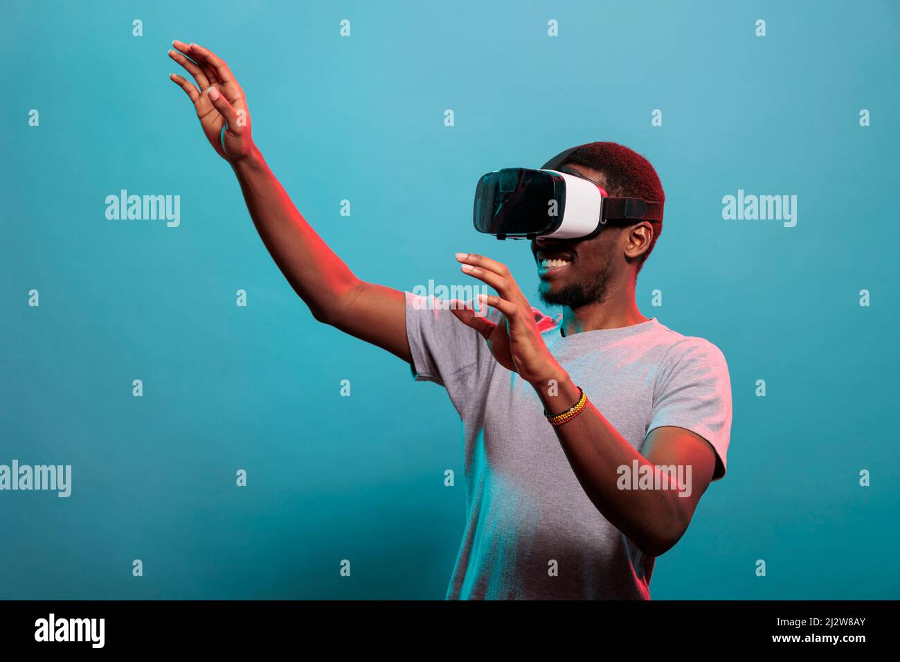 Cheerful model raising hands and playing with futuristic vr glasses to ...