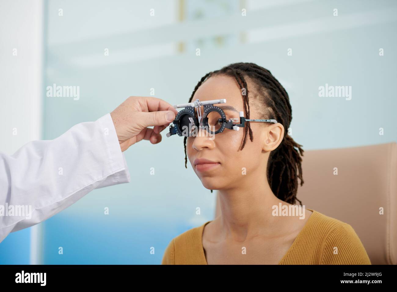 Ophthalmologist using adjustable optical trial lens frame to measure ...