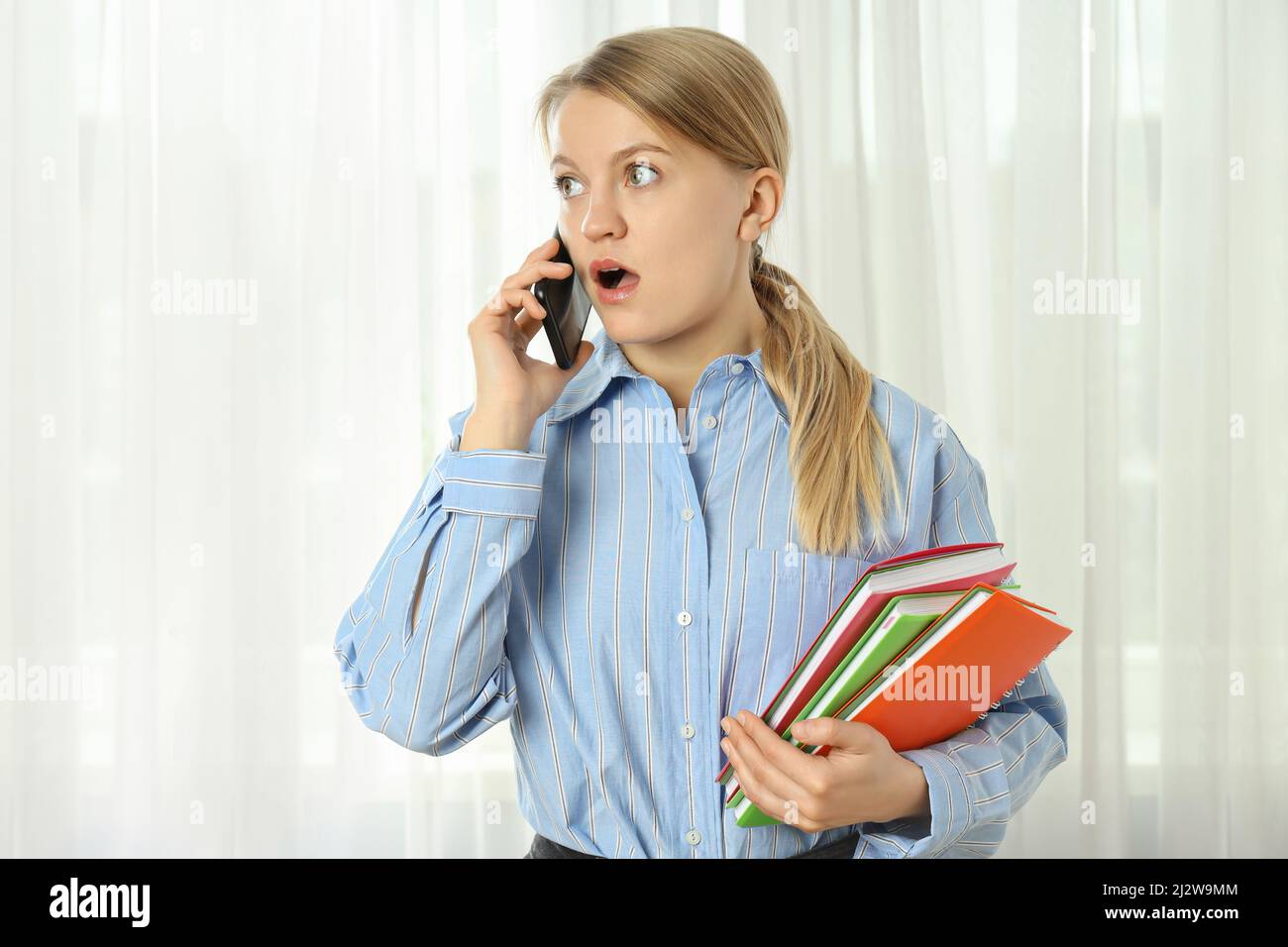Business woman in shock talking on phone Stock Photo - Alamy