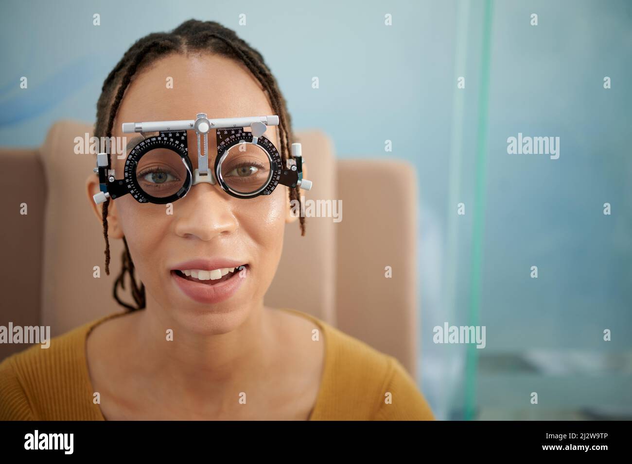 Portrait of smiling Black woman wearing adjustable optical trial lens ...