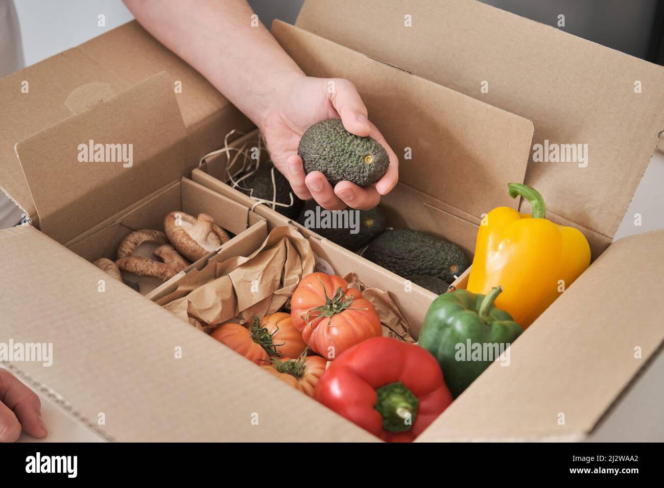 Unrecognizable man holding an avocado of a fruit and vegetable ...