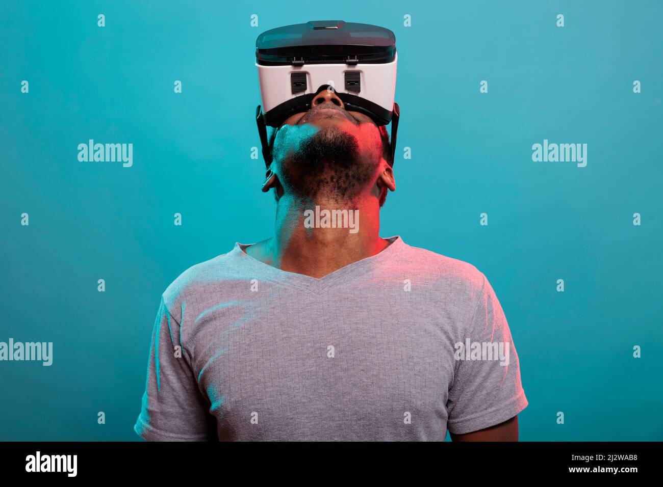 Male model looking up while he uses virtual reality glasses with ...