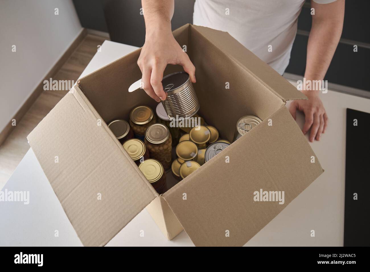 Unrecognizable man filling donation box with non-perishable food Stock ...