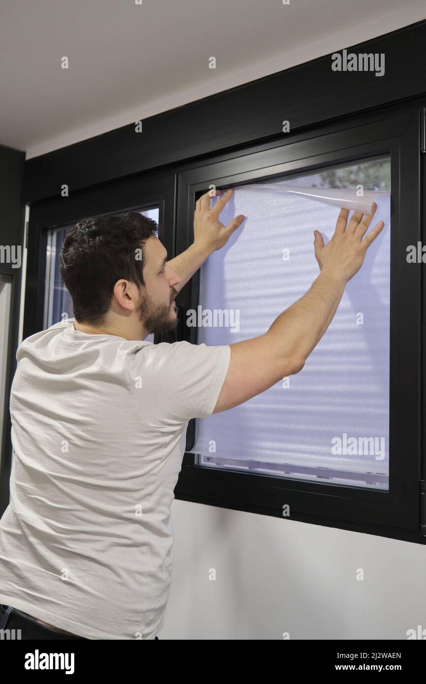 Man installing frosted window vinyl on window glass Stock Photo - Alamy