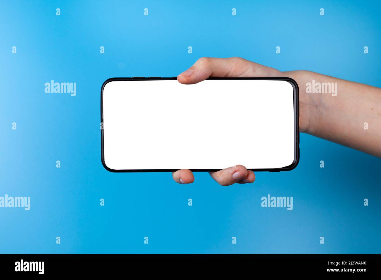 Smartphone in hand. White screen, blue background Stock Photo - Alamy