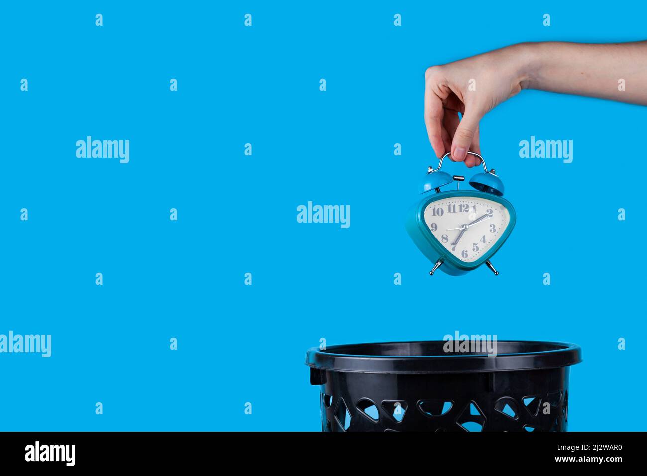 The alarm clock is thrown into the trash can Stock Photo - Alamy