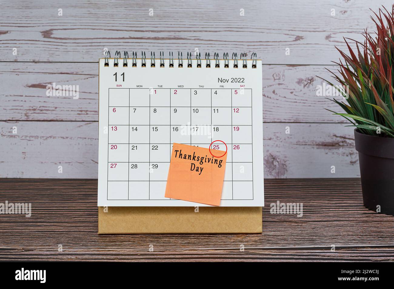 November 2022 calendar on wooden desk with date circle and text on ...