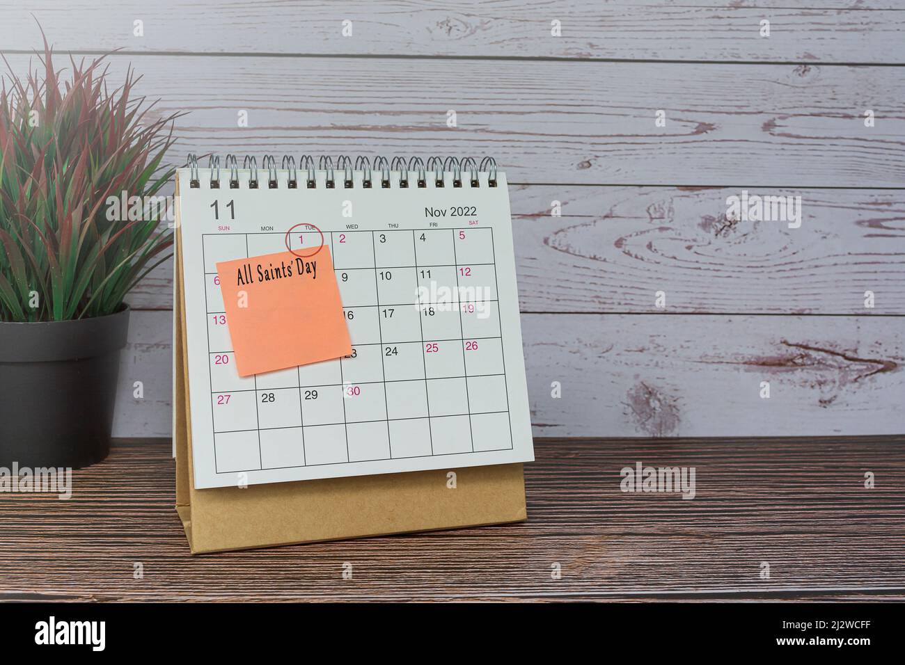 November 2022 calendar on wooden desk with date circle and text on ...