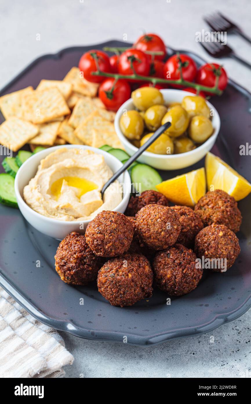 Falafel platter with hummus, olives, crackers and vegetables, close-up ...