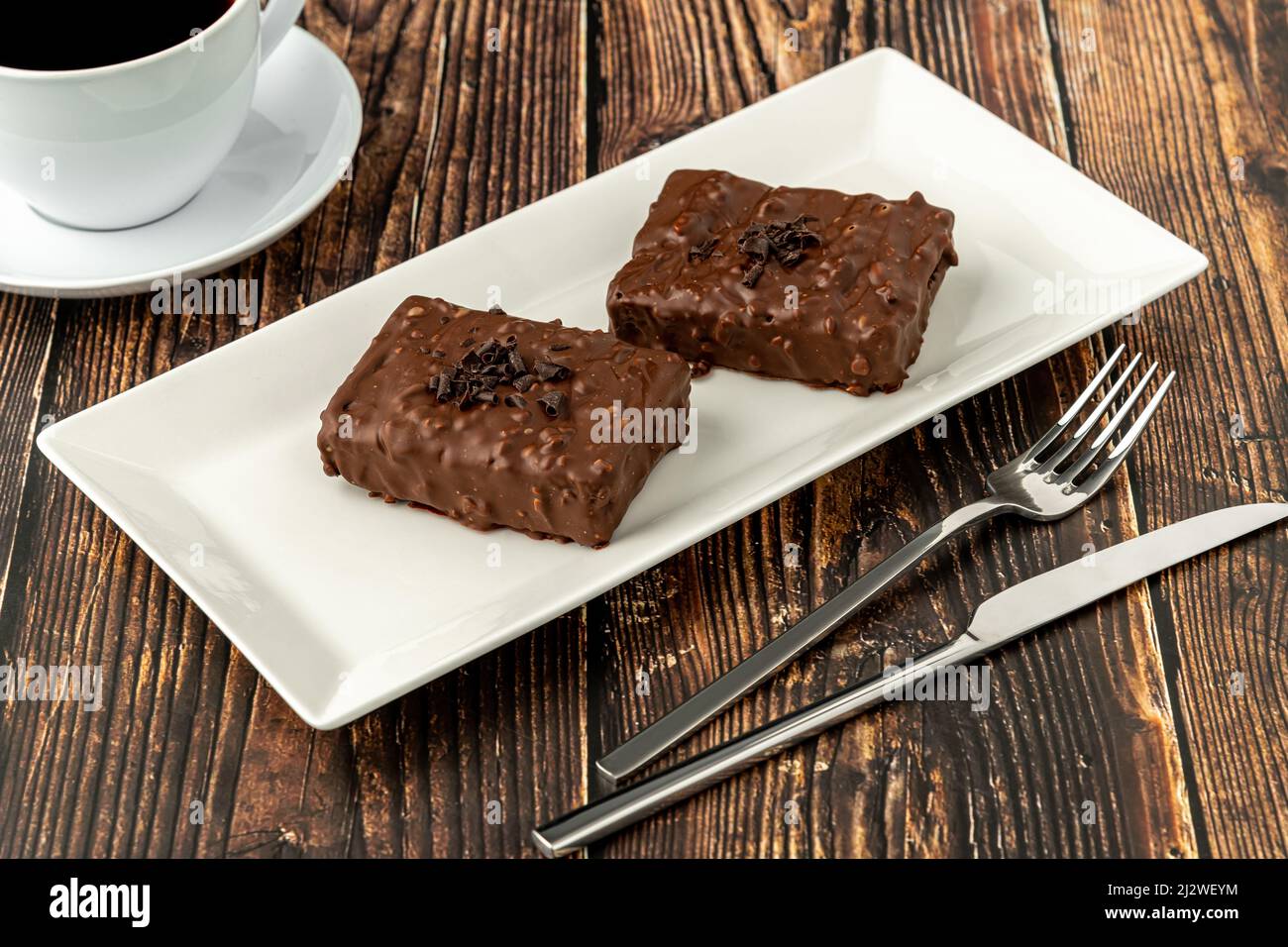 Chocolate covered raisin cake on wooden table with filter coffee Stock ...