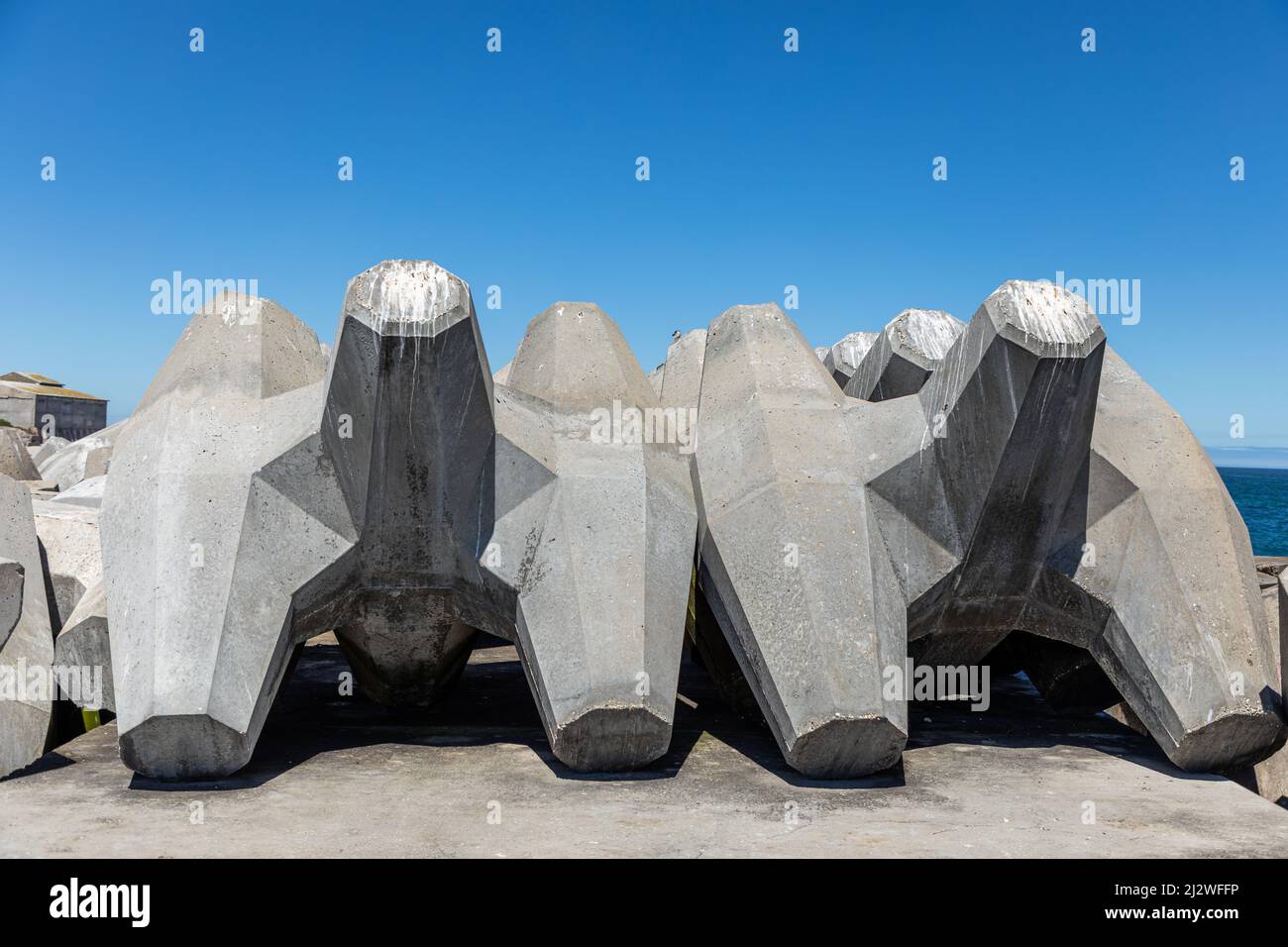 Selective focus on two large concrete dolos. Dolos is used as break ...