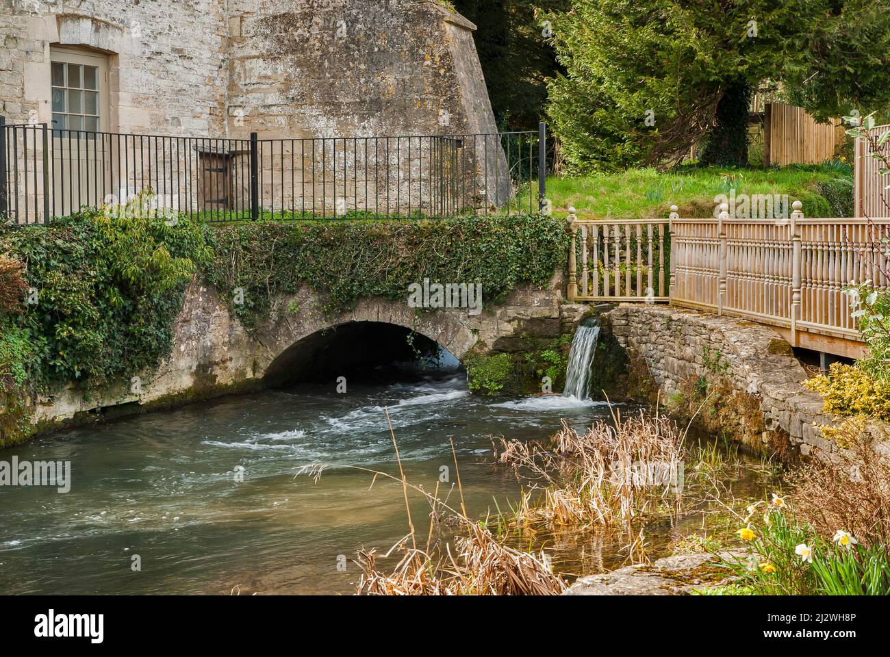 River passing old stone medieval houses in British provincial village ...