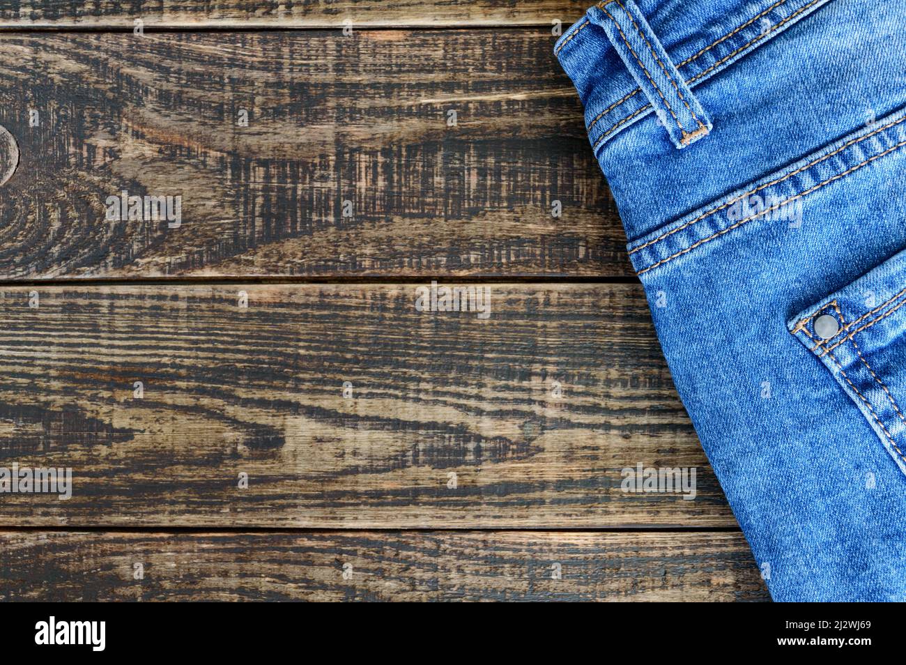 Blue cotton jeans on a rustic wooden background with copy space Stock ...