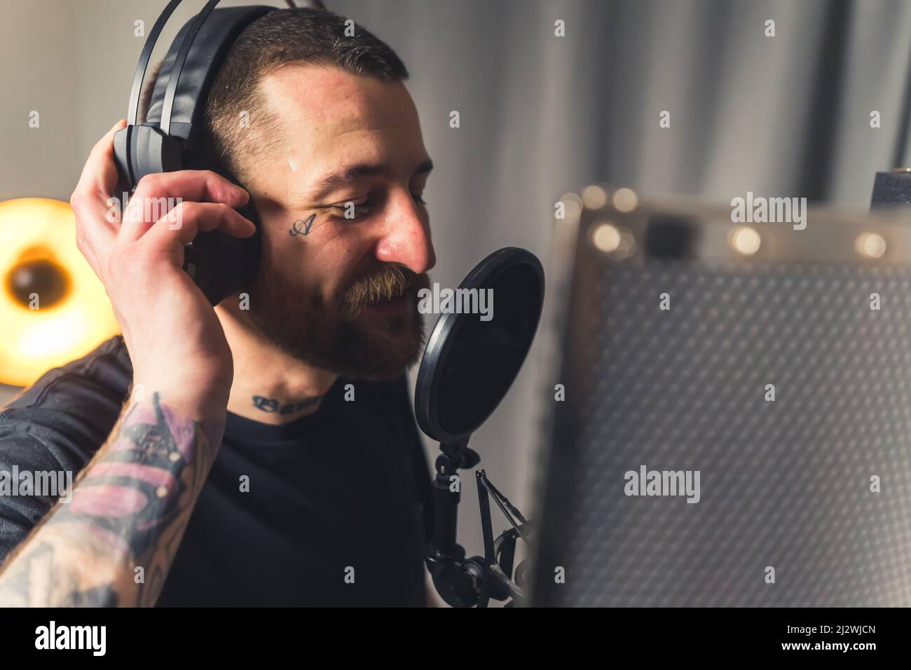 Male creator concept. Rapper in a studio recording his new diss track ...